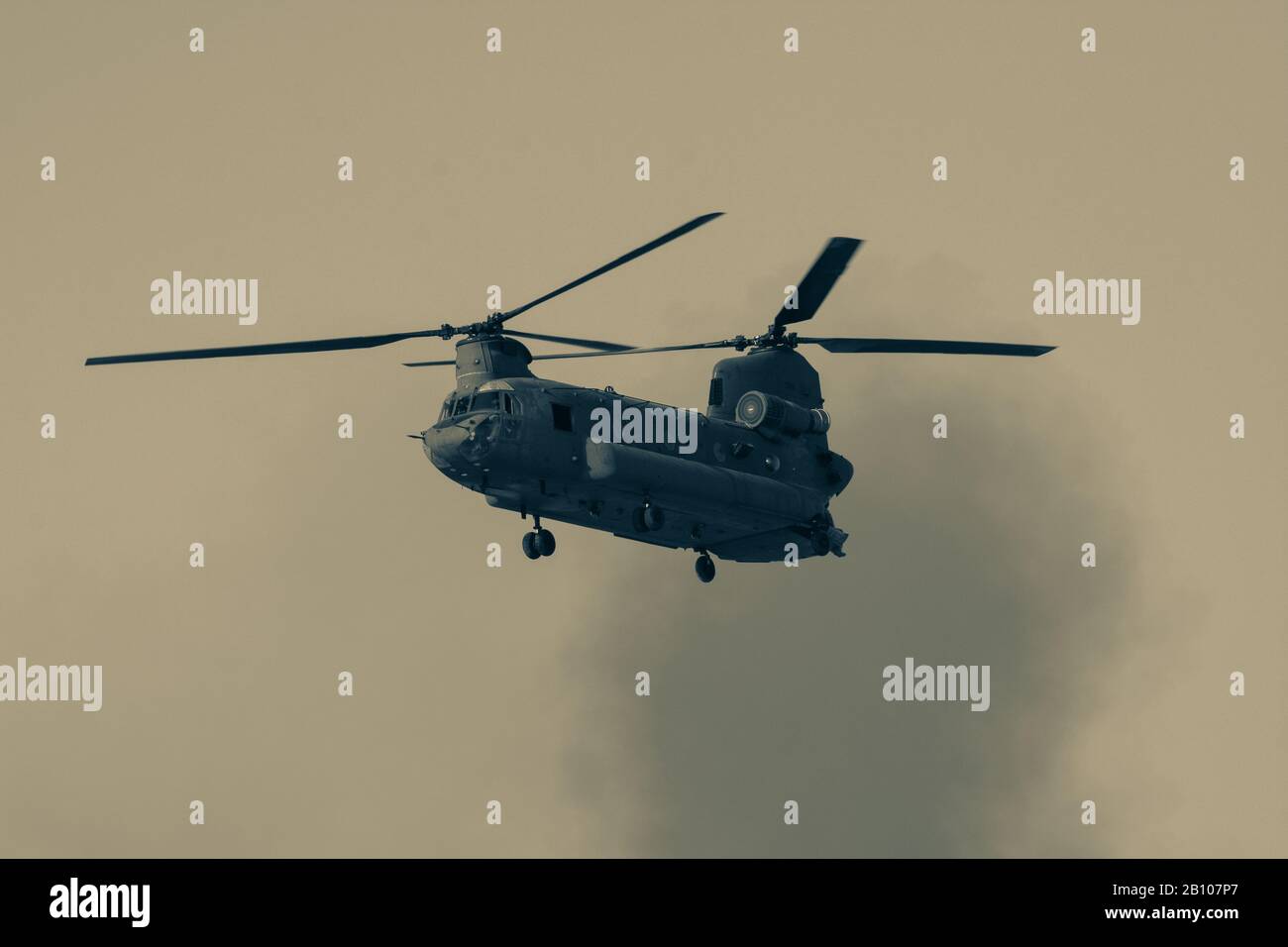 Military combat and war with Chinook helicopter flying through the ...