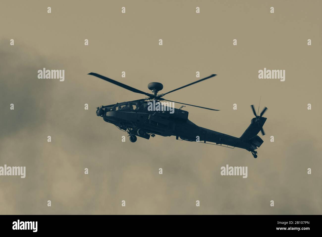Military chopper close up in war flies through the smoky hazy sky in ...
