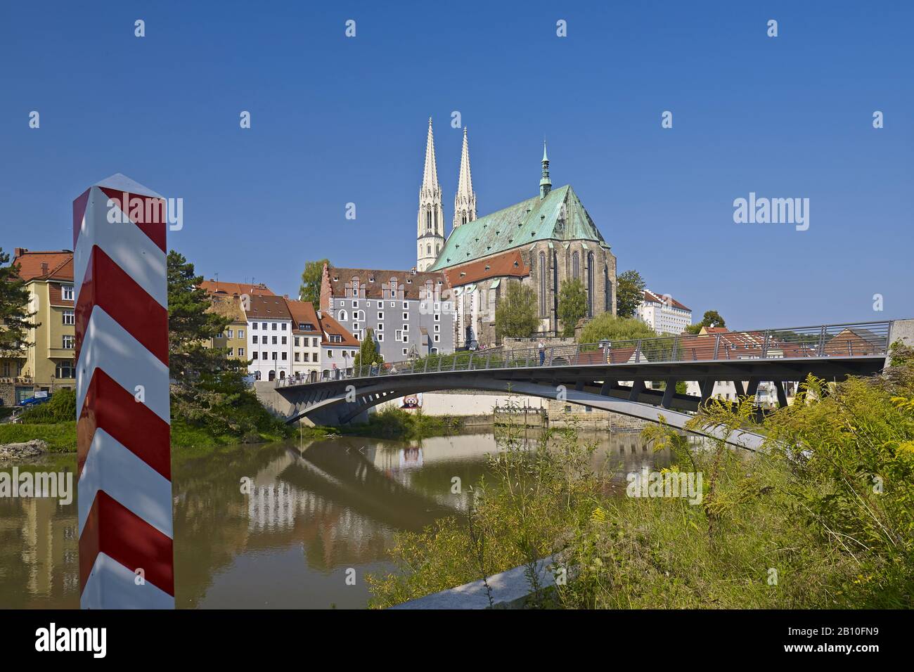 Bridge over the river Neisse to the old town with church St. Peter and ...