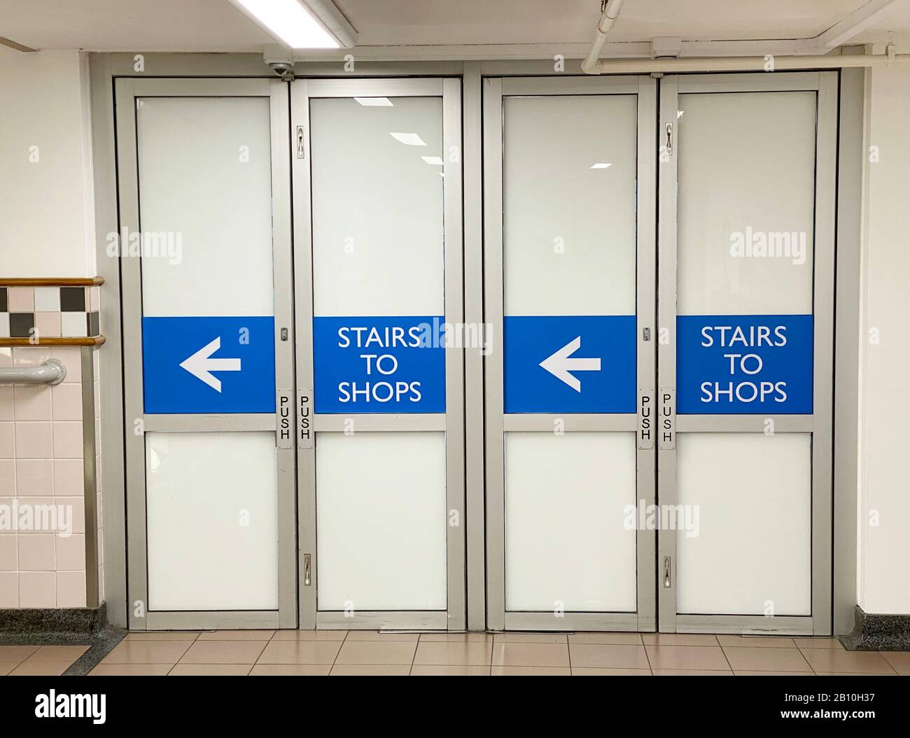 Direction arrow sign to shops from stairs at shopping mall Stock Photo ...