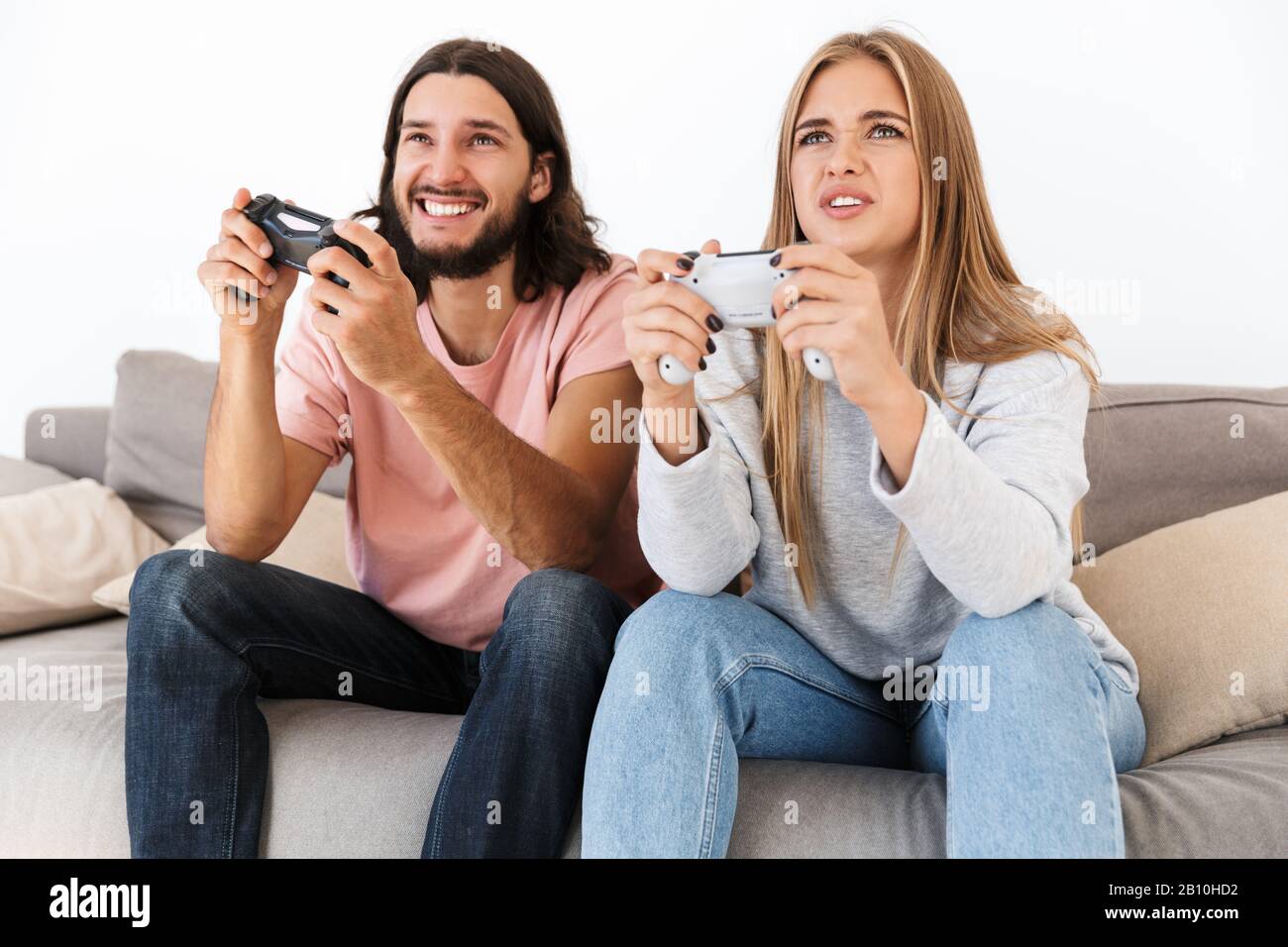 Photo of nervous young loving couple on sofa play video games with ...