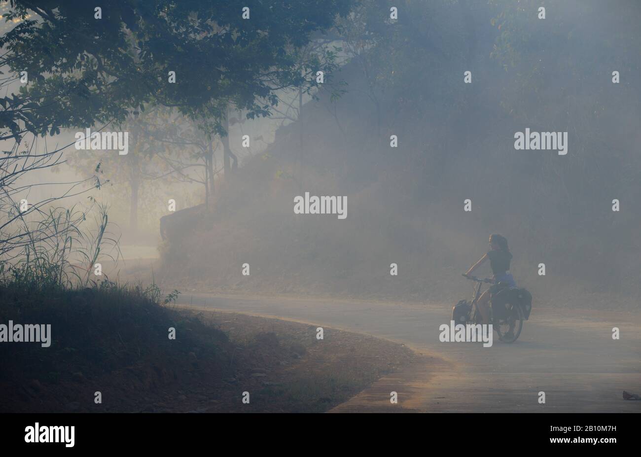 Cyclists in the fog after weed burning, Northern Luzon, Philippines ...