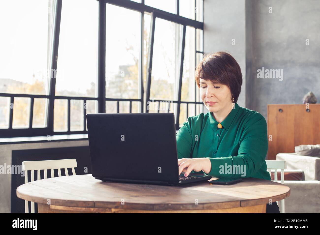 Confident mature woman working laptop computer indoors Stock Photo - Alamy