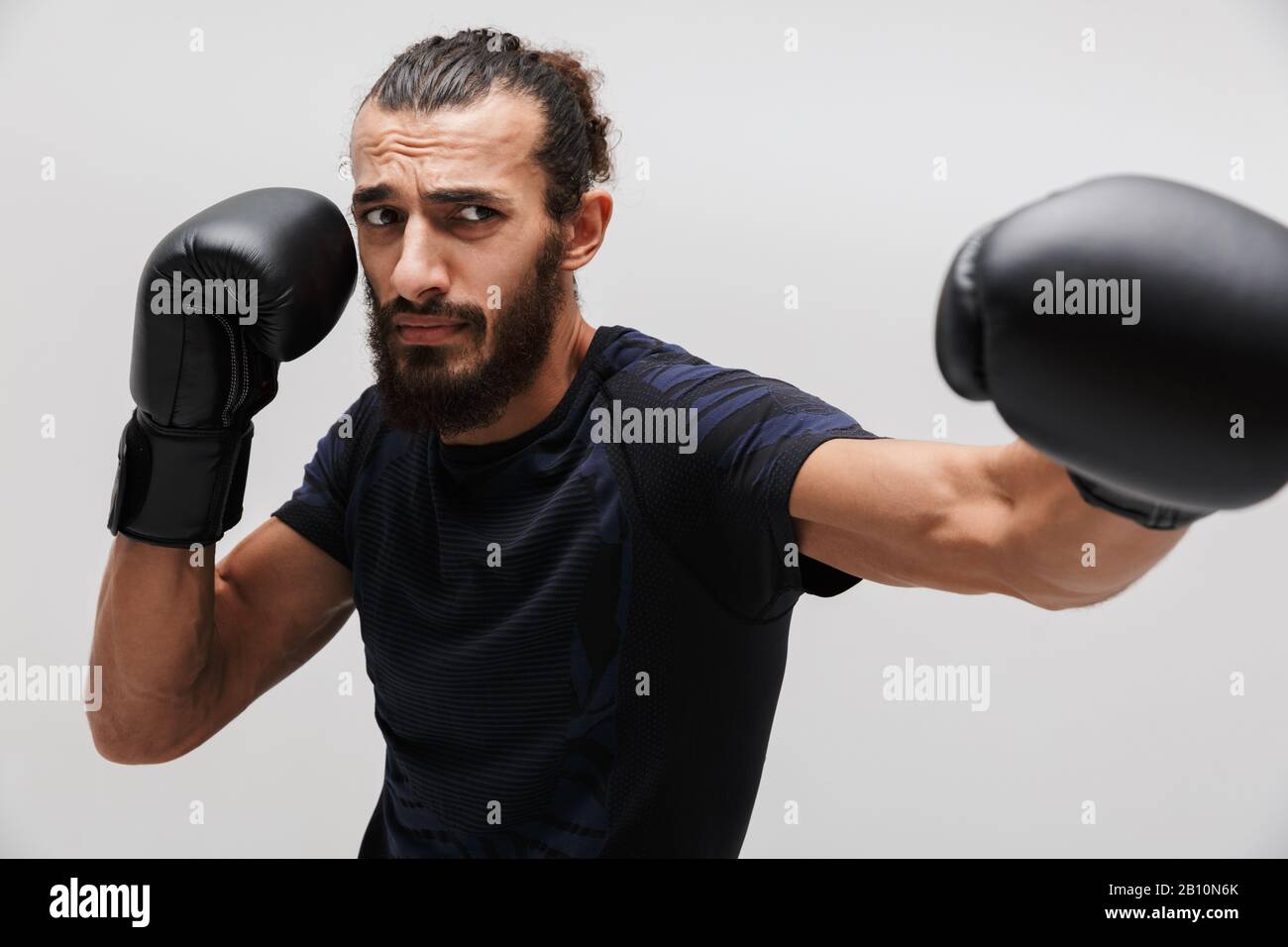 Image of serious muscular sportsman wearing tracksuit boxing in gloves ...