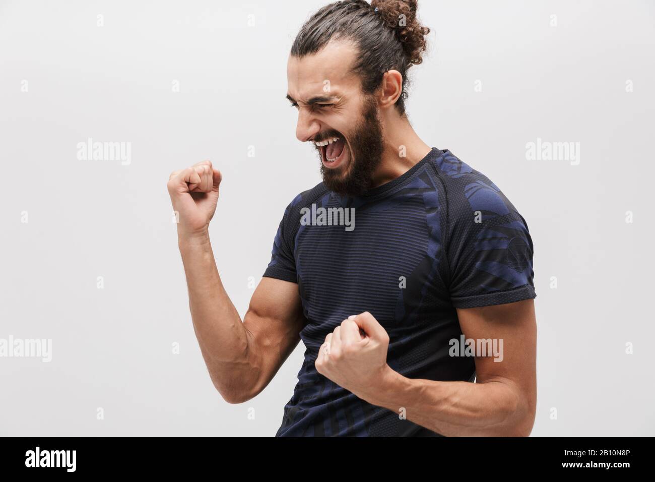 Image of cheerful brunette sportsman wearing tracksuit screaming and ...
