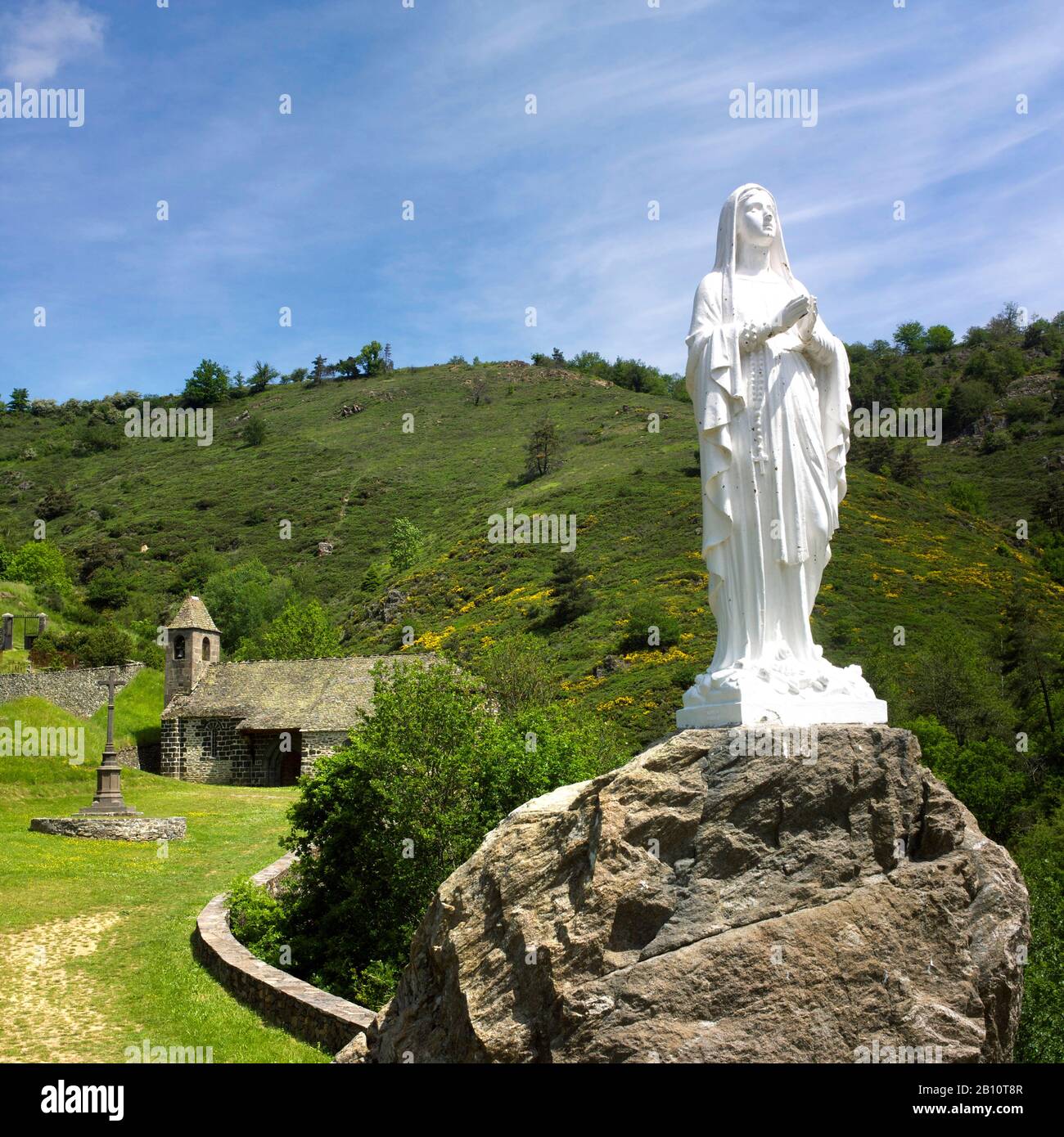 Statue of the virgin Mary in front of church near castle of Alleuze in ...