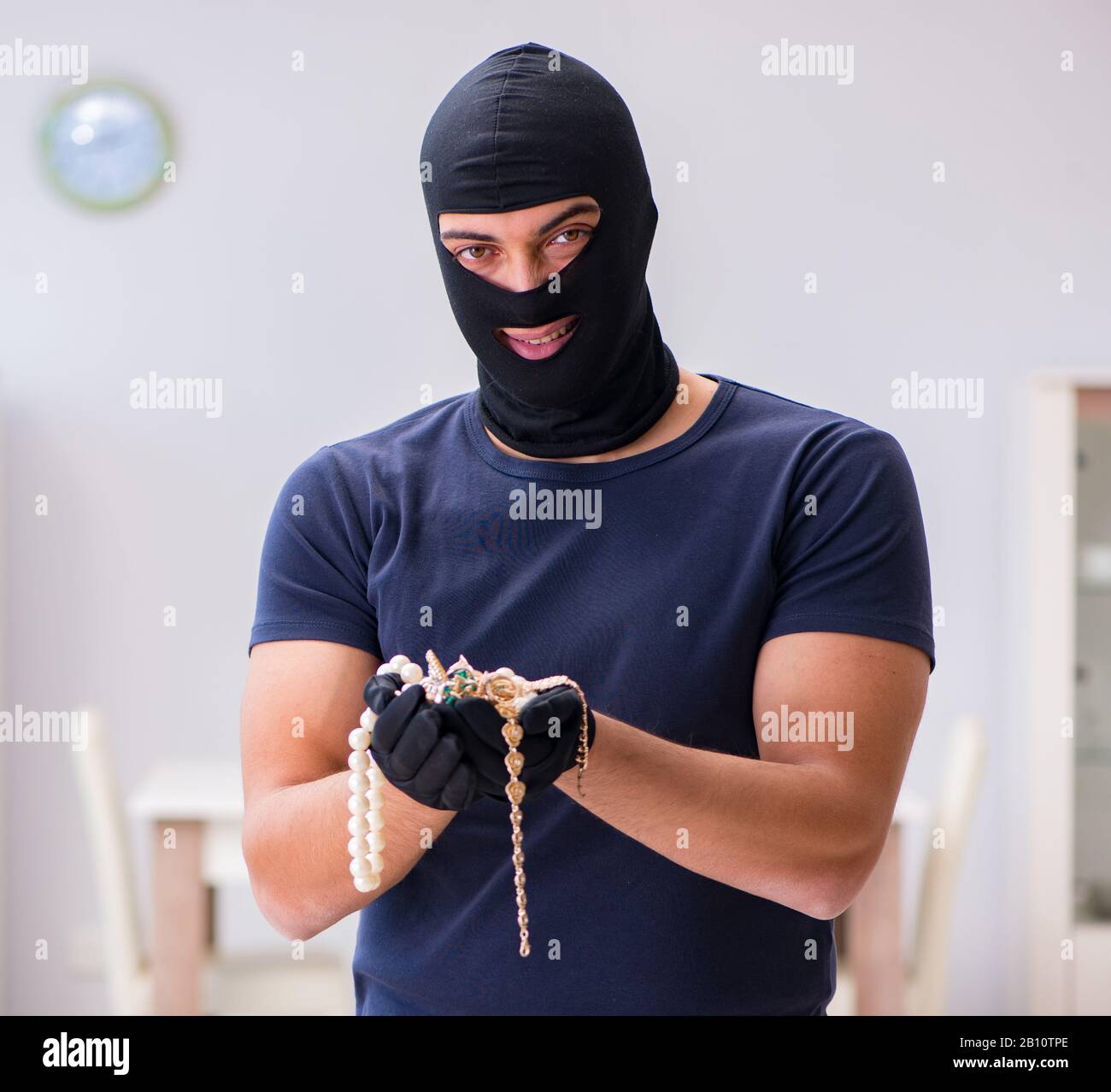 The robber wearing balaclava stealing valuable things Stock Photo - Alamy