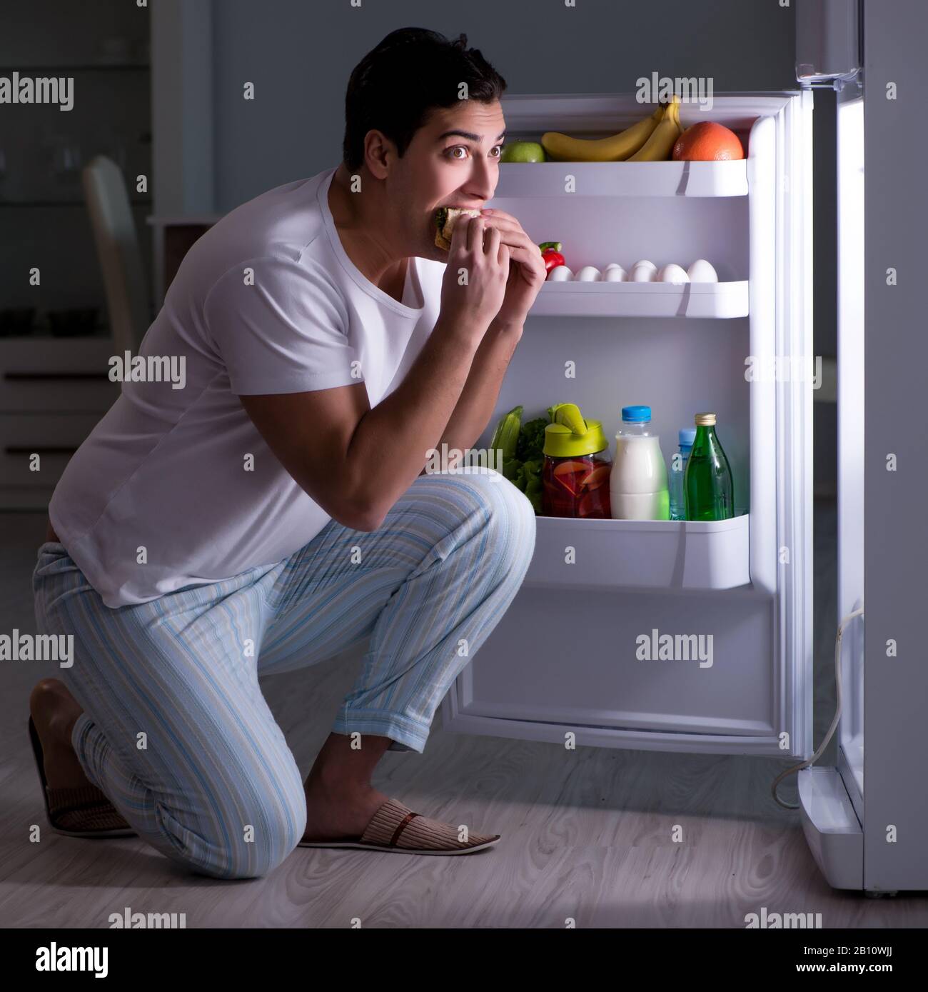 Man opening refrigerator at night hi-res stock photography and images ...