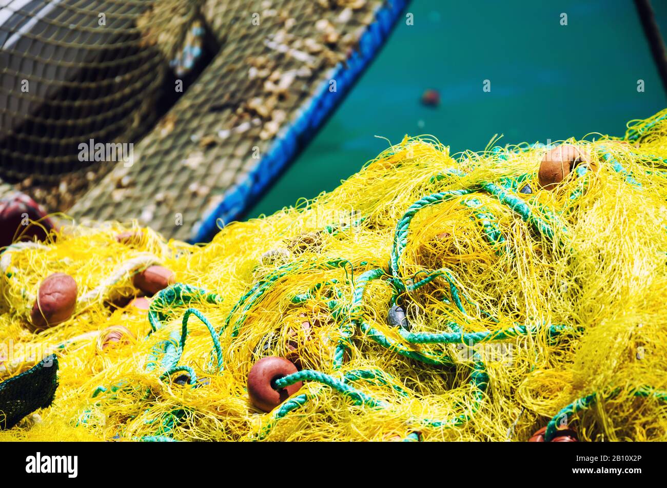 Fishnet lying near fishing boat Stock Photo - Alamy