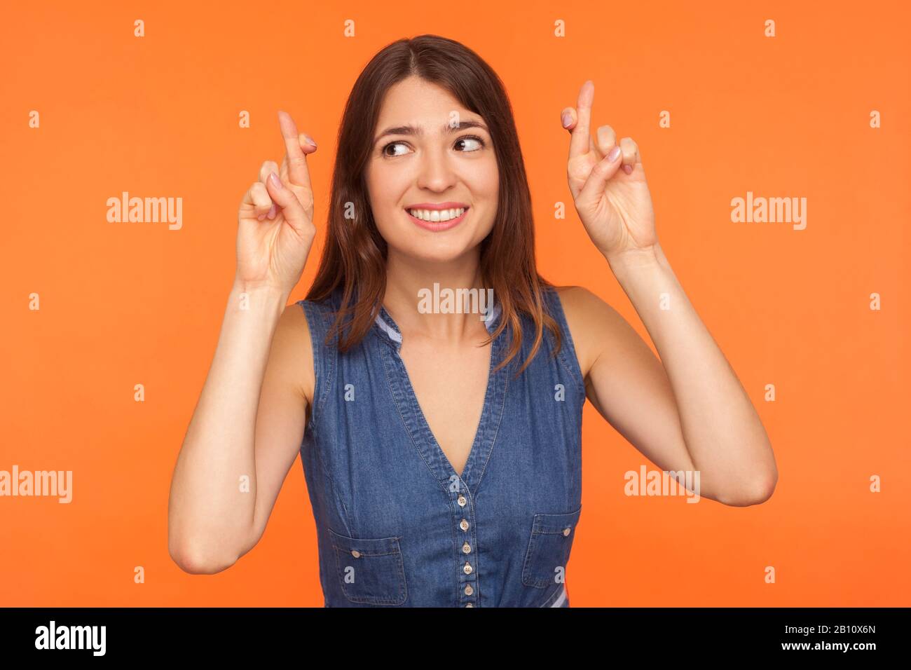 Cute positive brunette woman smiling happily and holding fingers ...