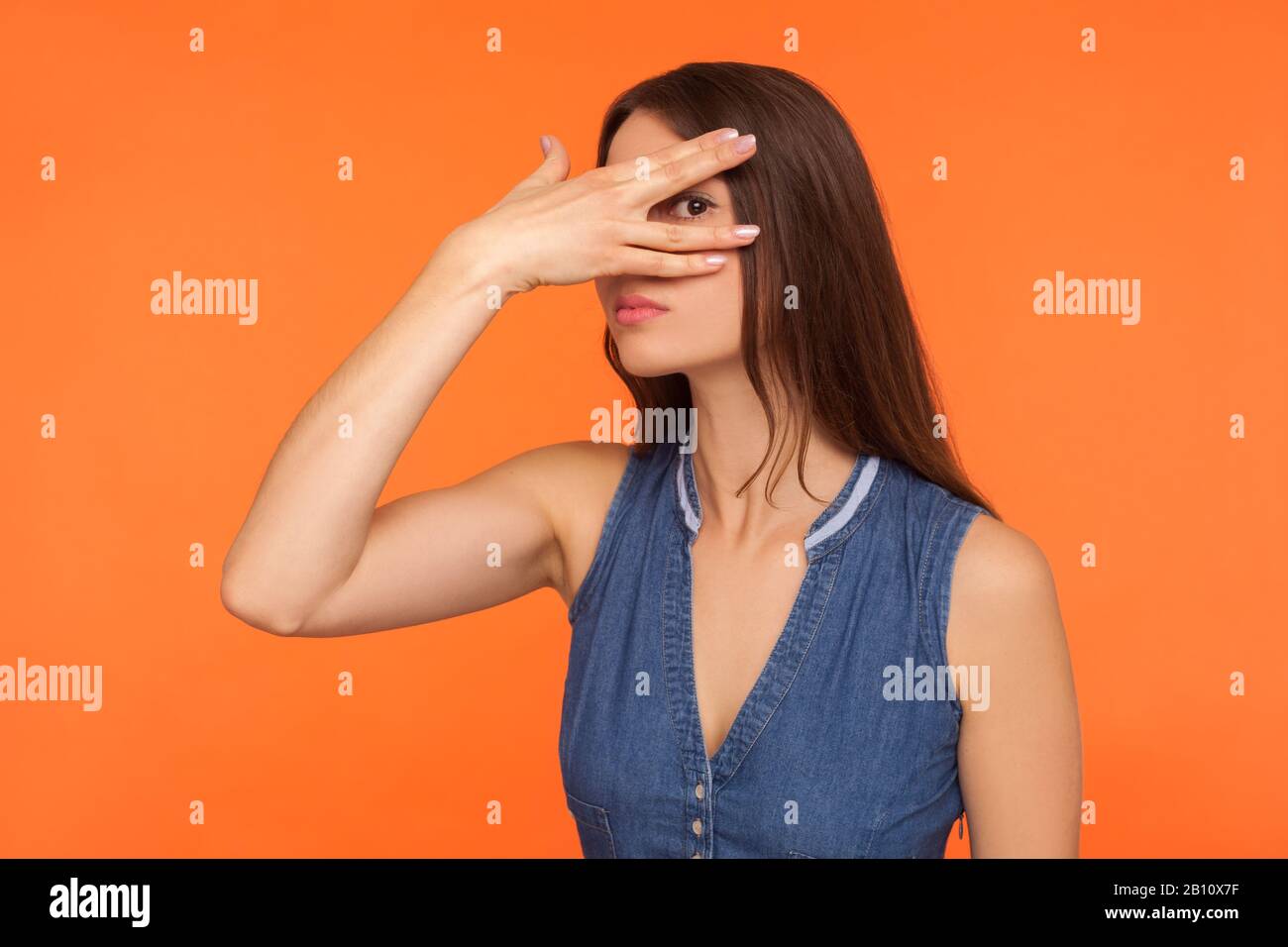Curious nosy brunette woman in denim dress spying secrets, looking ...