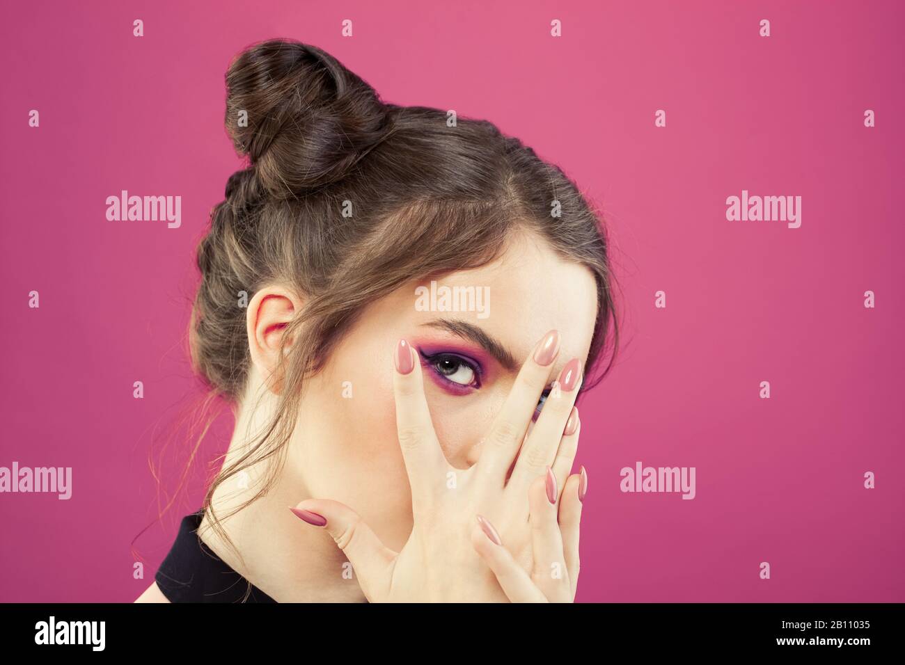 Beautiful model girl with fashion makeup hiding behind hands with ...
