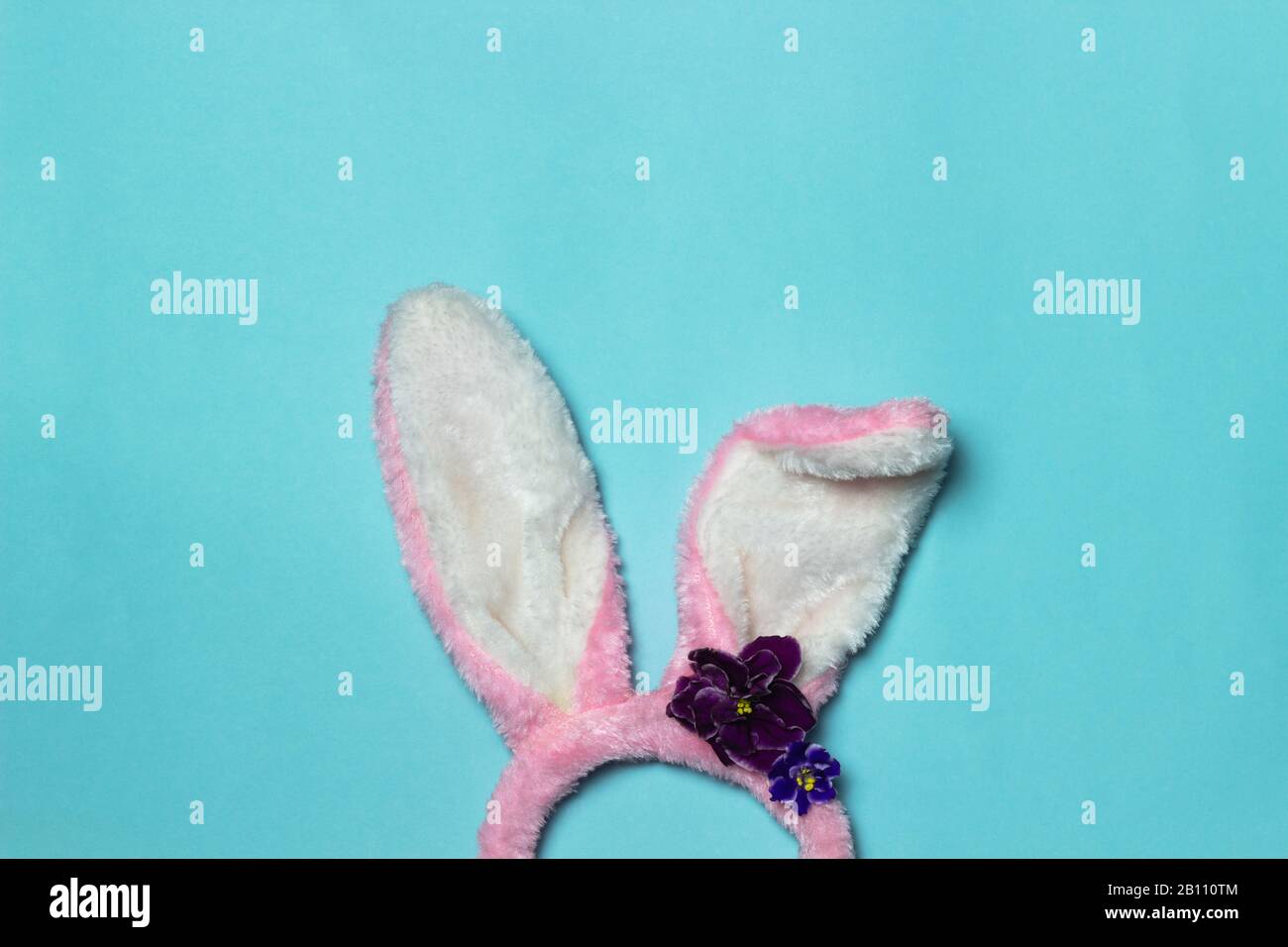 Pink bunny ears headband with violets on blue background. Easter ...