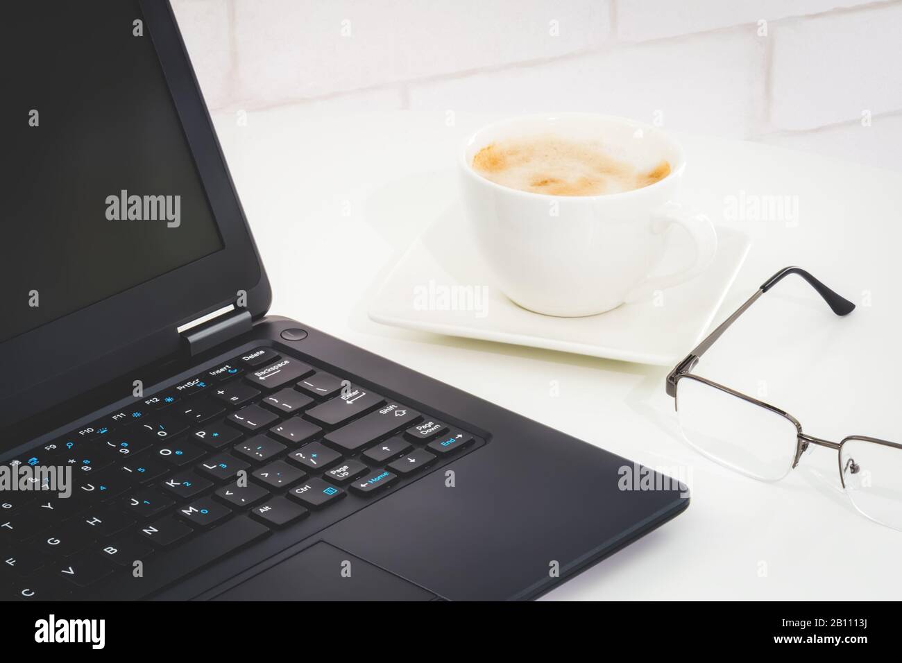 Office desktop with laptop, eye glasses and a cup of coffee Stock Photo ...