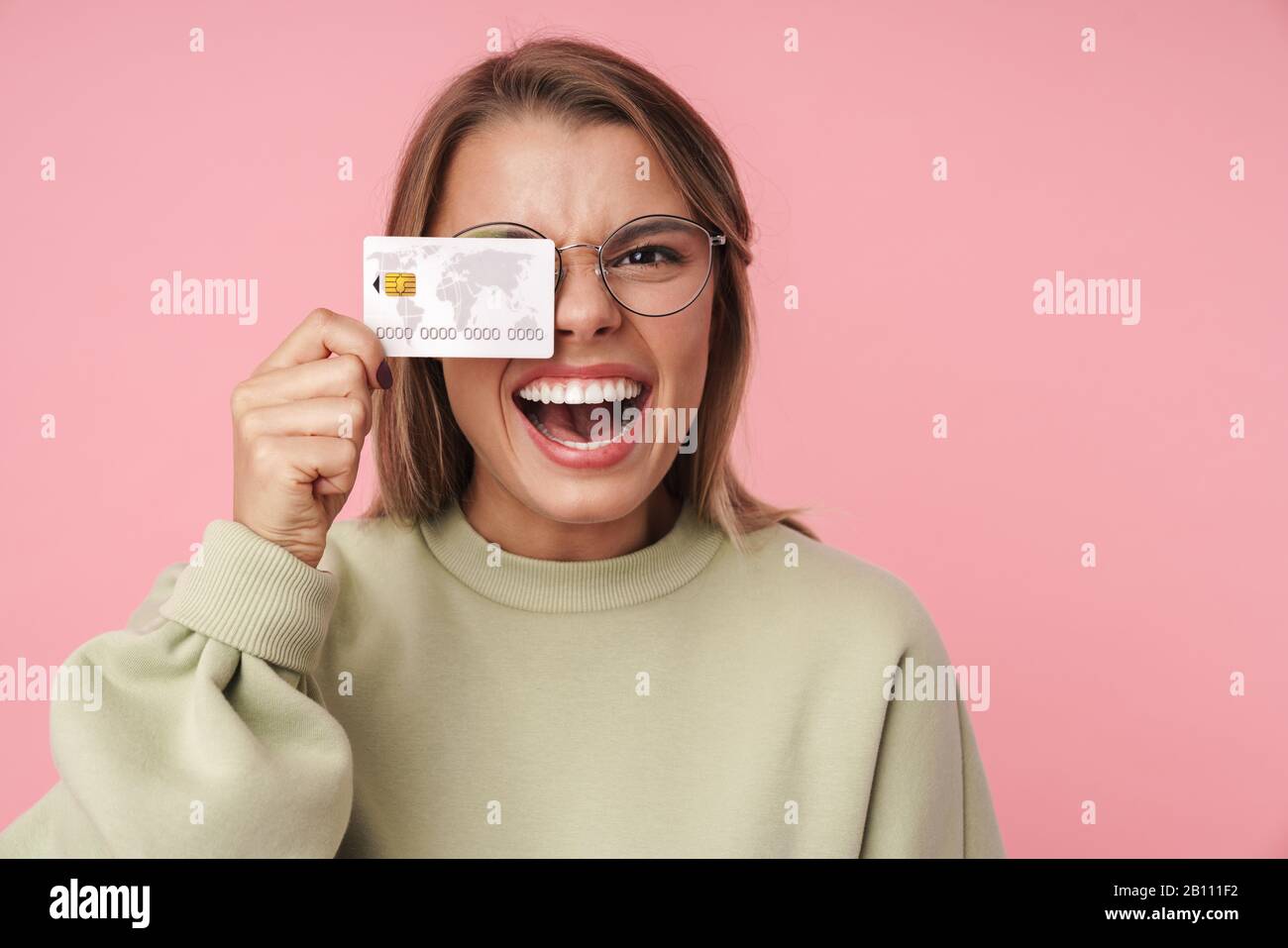 Portrait of nice excited woman in eyeglasses holding credit card while ...