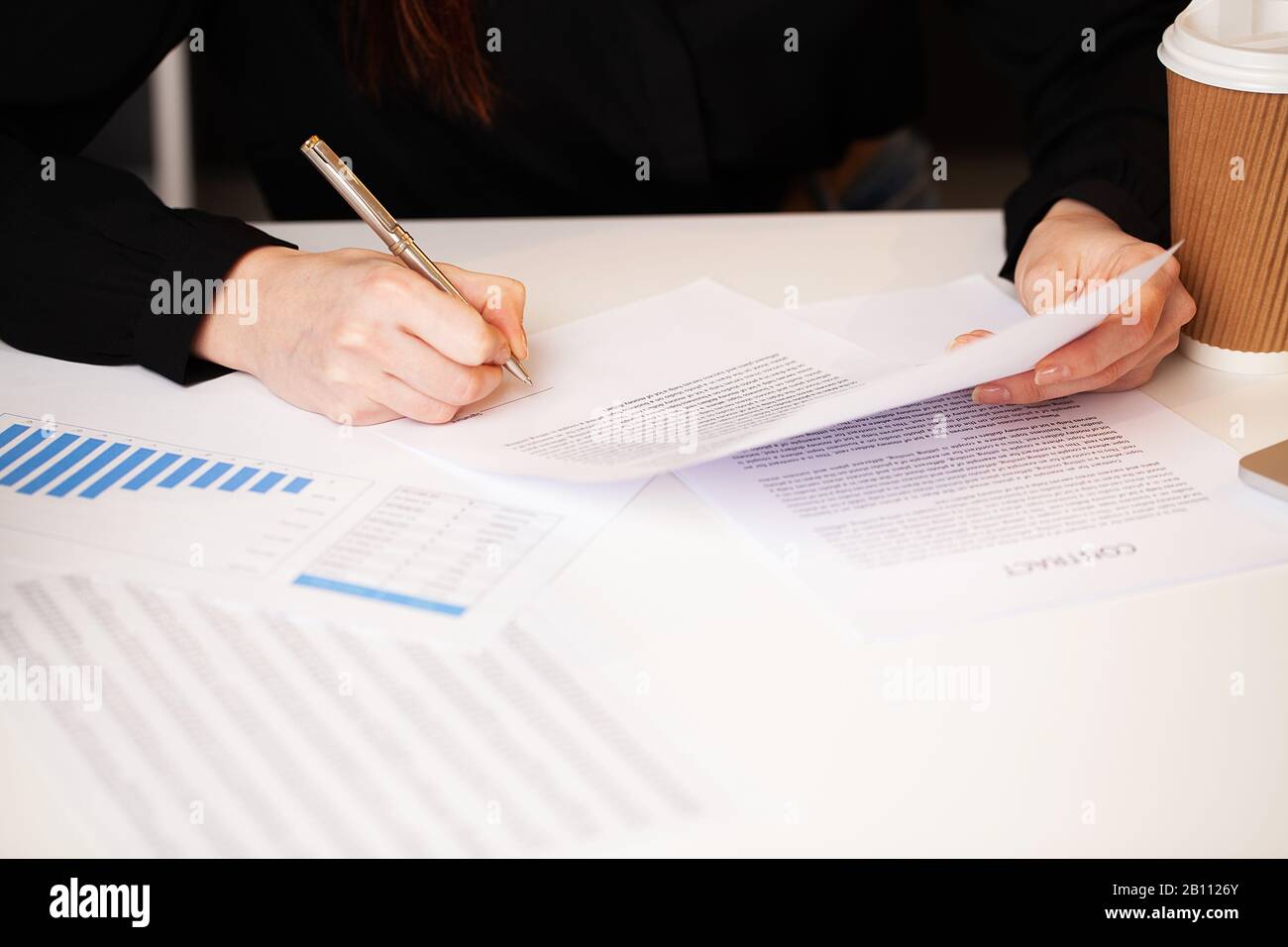 Man signs a contract at a desk in a company office Stock Photo - Alamy