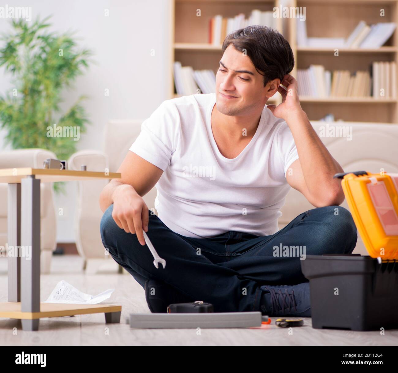 The man assembling shelf at home Stock Photo - Alamy