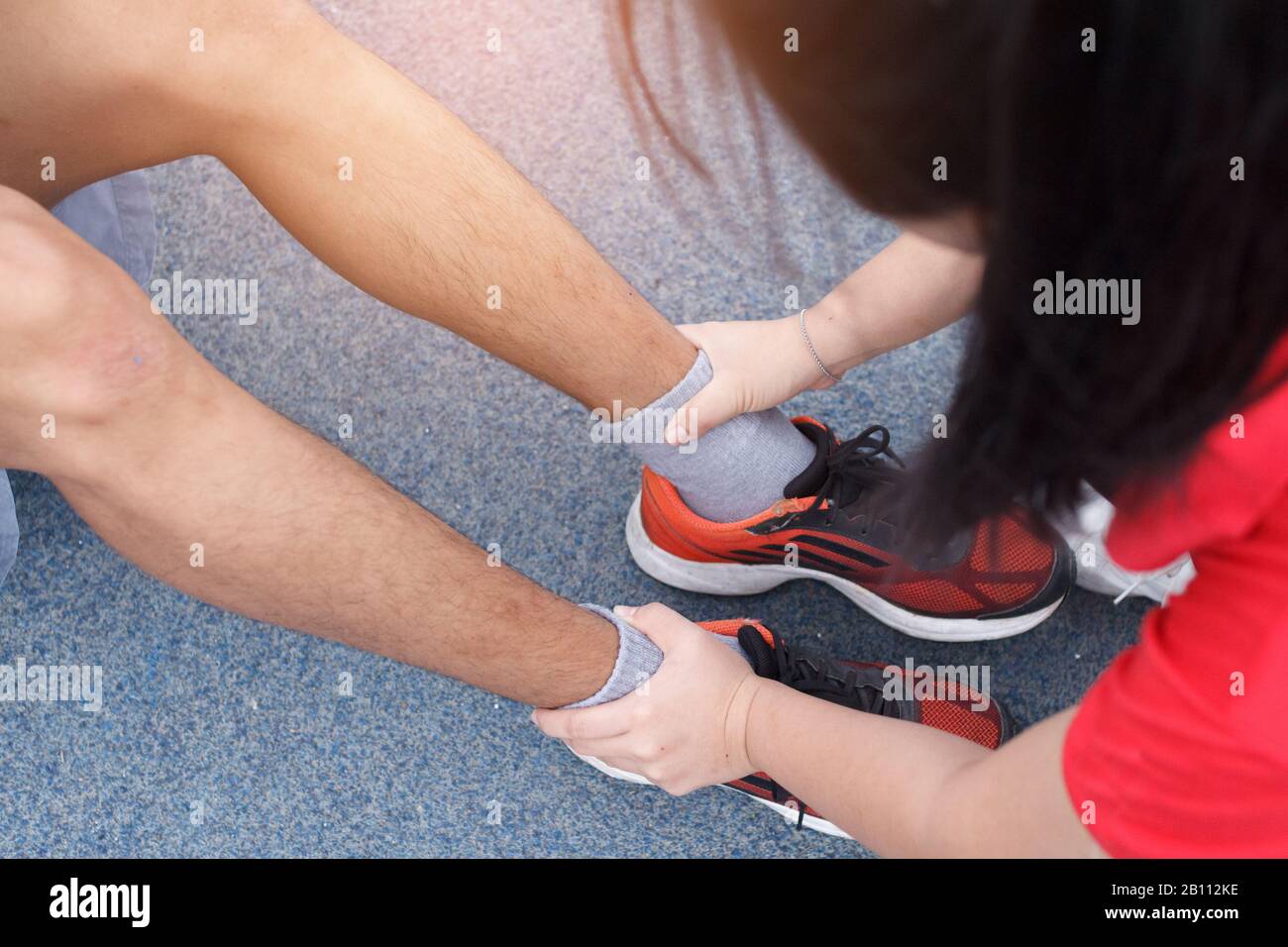 Young woman try to lock ankle of her friend to situp. Workout concept ...