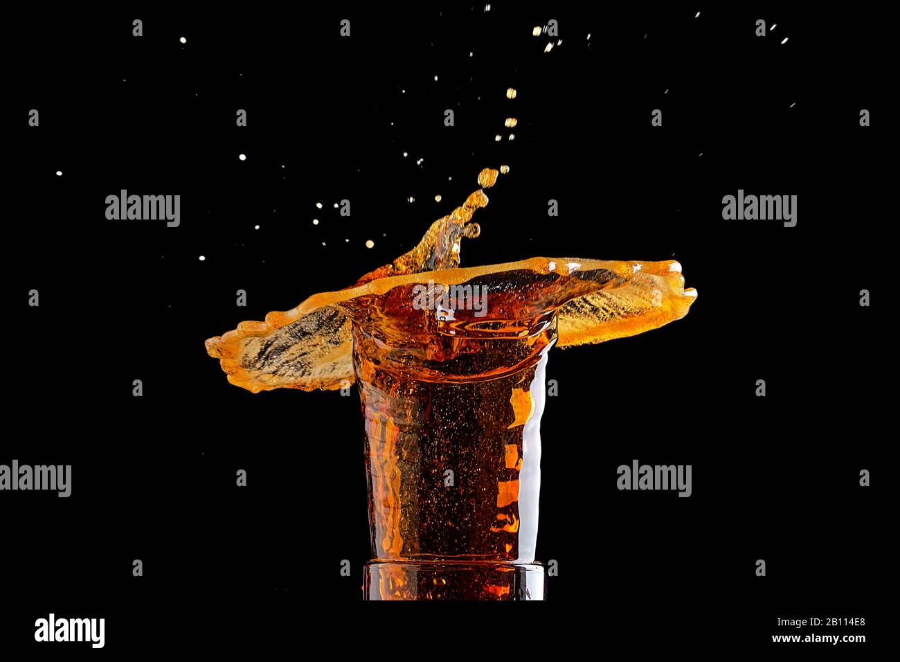 Beer splash in glass on black background Stock Photo - Alamy