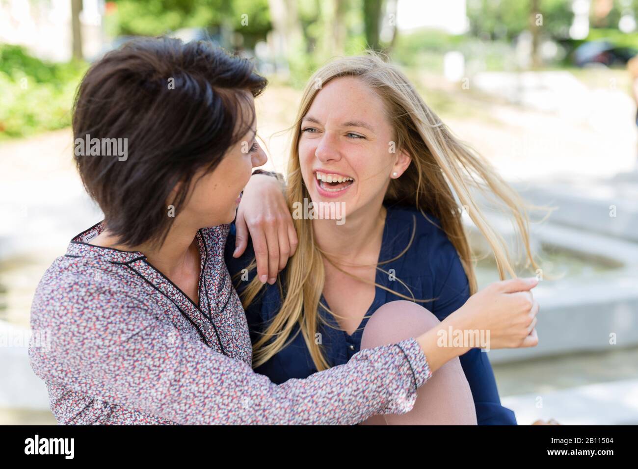 Two friends laugh together and talk Stock Photo - Alamy