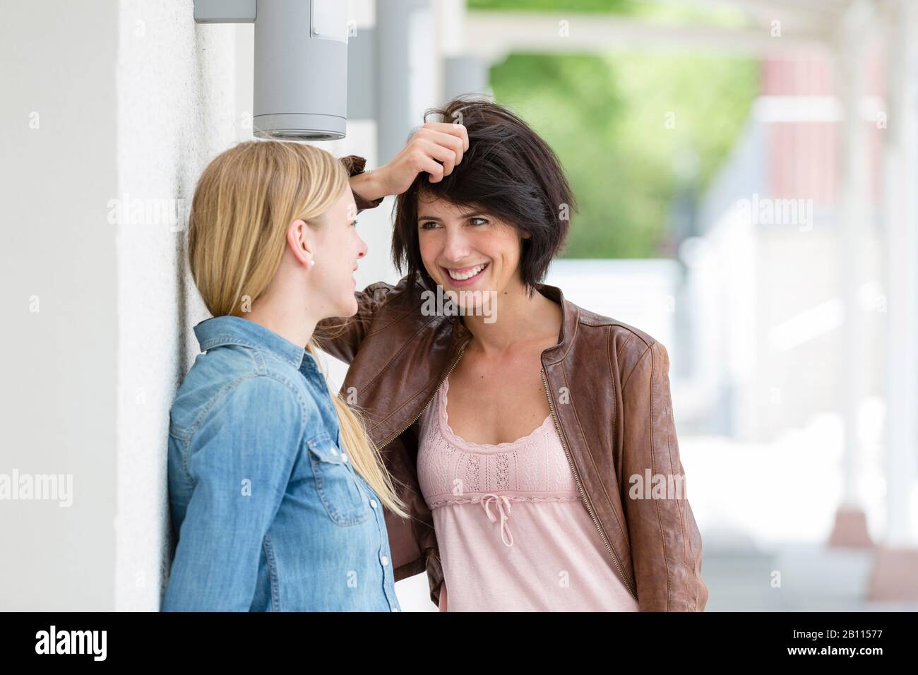 Two friends laugh together and talk Stock Photo - Alamy