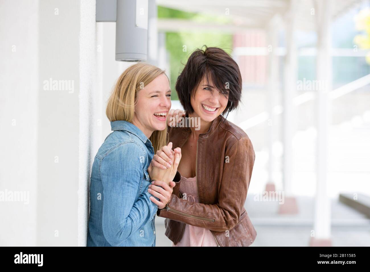 Two friends laugh together and talk Stock Photo - Alamy