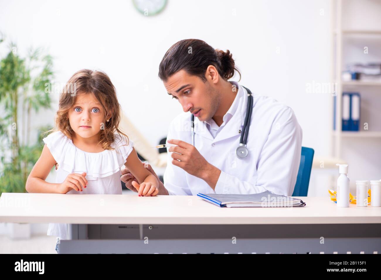The young doctor pediatrician with small girl Stock Photo - Alamy