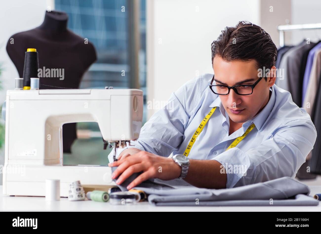 The young man tailor working on new clothing Stock Photo - Alamy