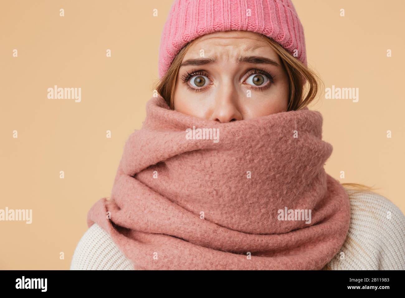 Image of young caucasian girl wearing winter hat and scarf frowning and ...