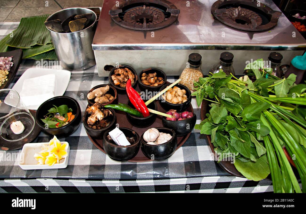 Cooking class, different spices in bowls around old gas stove on table ...