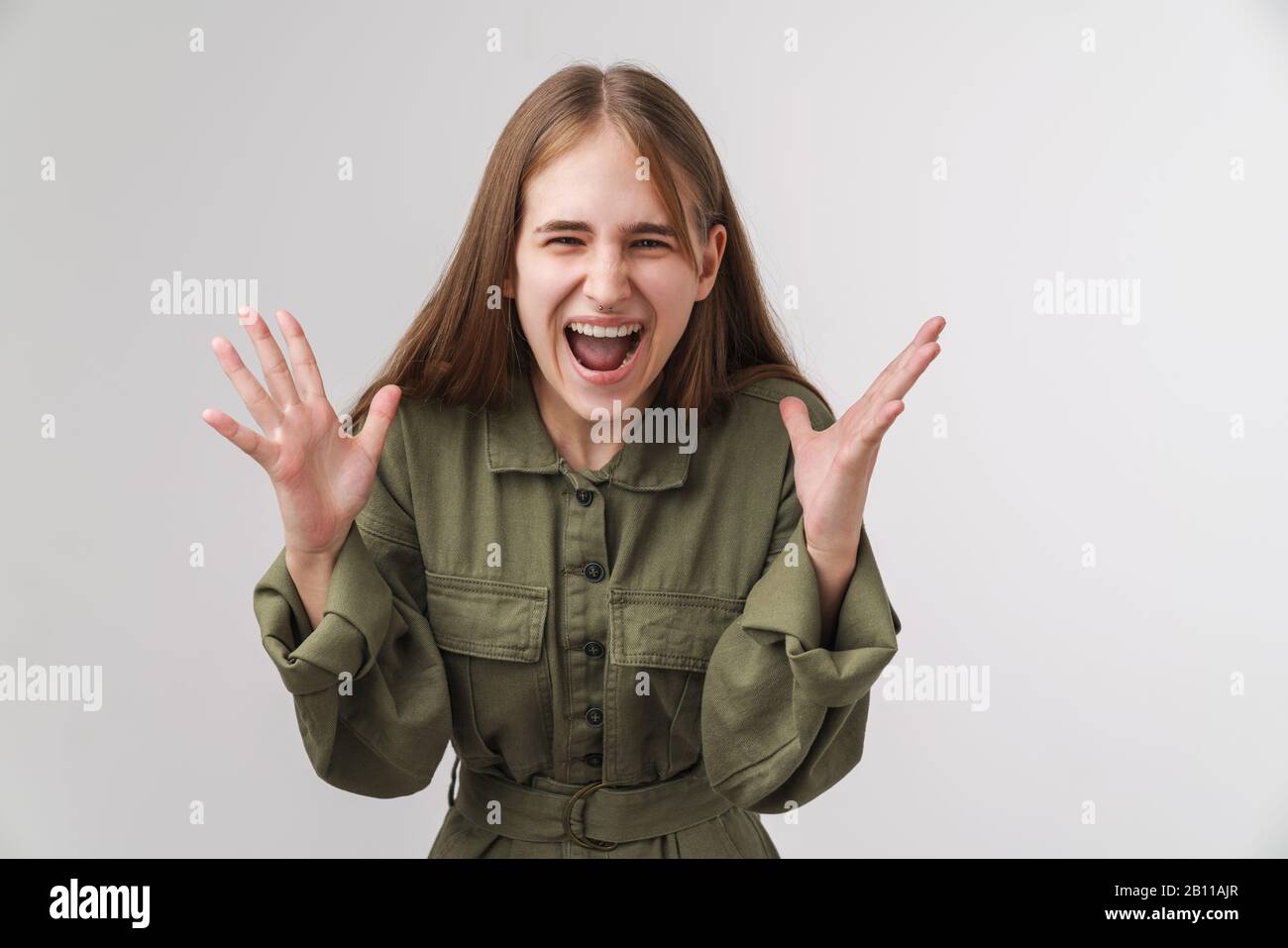 Photo of annoyed young woman screaming at camera with hands up isolated ...
