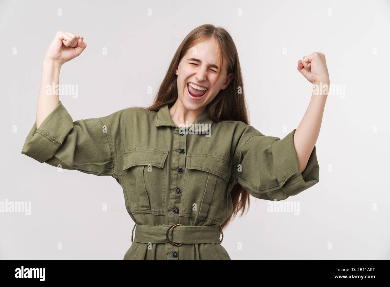 Photo of excited cute woman making winner gesture and screaming ...