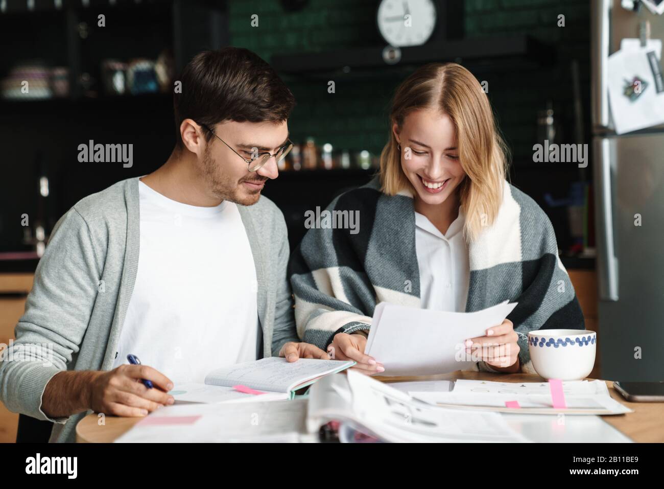 Image of happy young businesslike man and woman doing calculations and ...