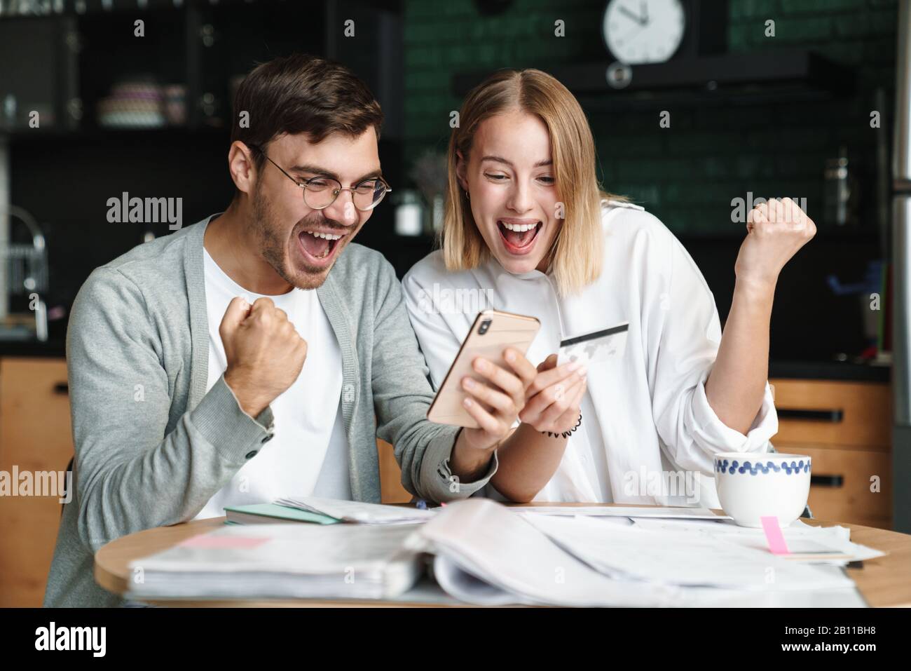 Image of happy young businesslike man and woman doing calculations and ...