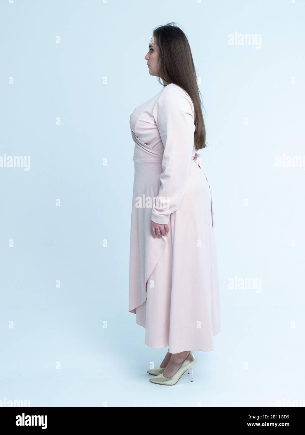 Plus Size woman in pink dress posin like Model in studio. Model tests ...