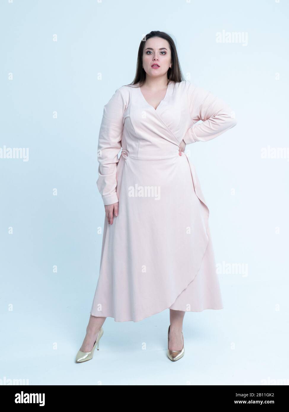 Plus Size woman in pink dress posin like Model in studio. Model tests ...