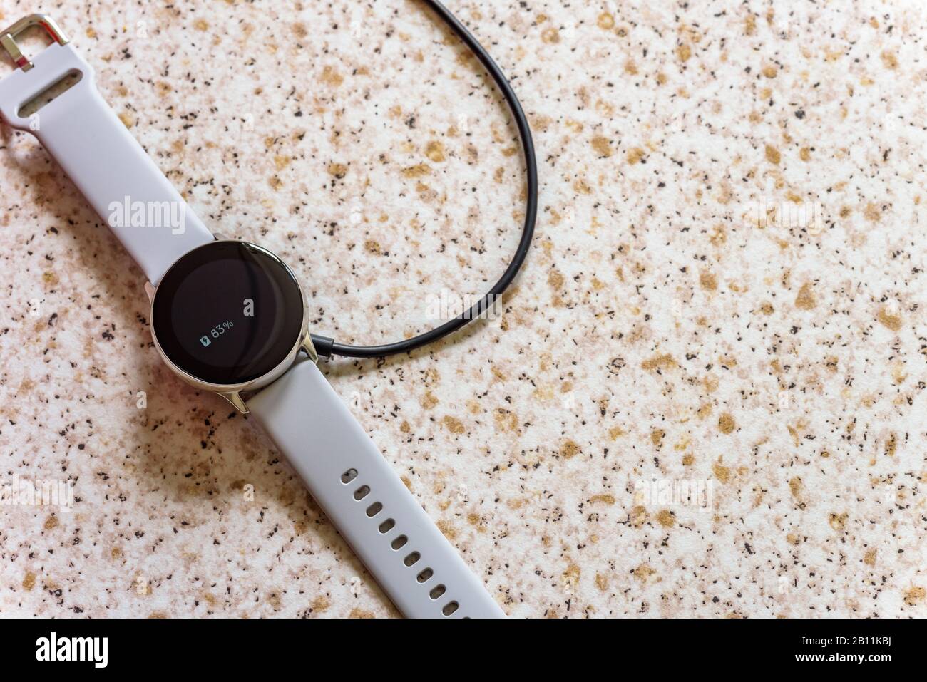 smart watch wireless charging on charging pad on kitchen worktop table ...