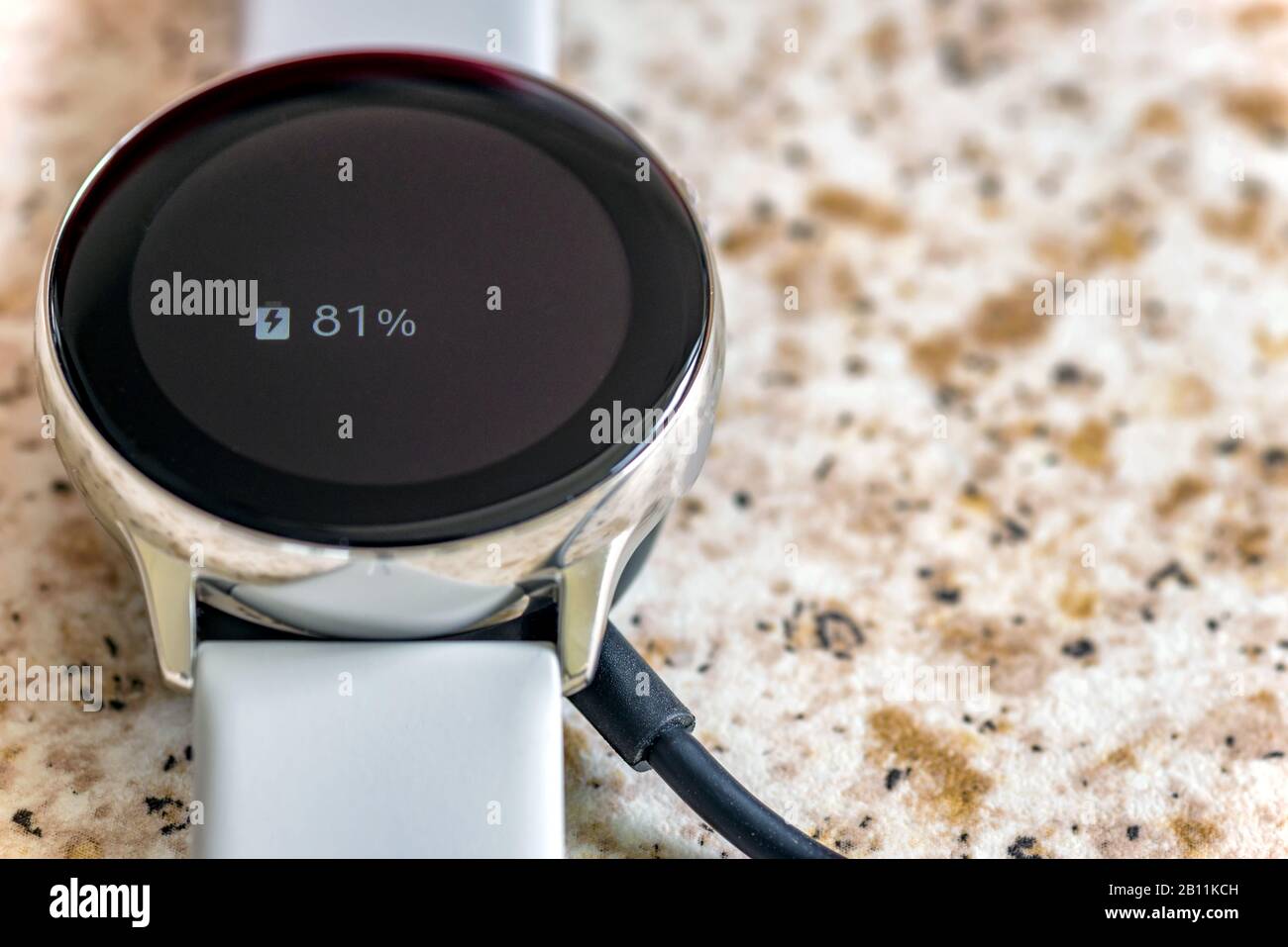 smart watch wireless charging on charging pad on kitchen worktop table ...