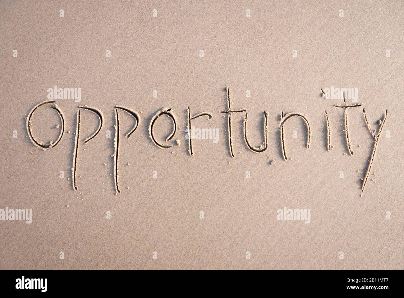 Opportunity message handwritten on smooth sand beach Stock Photo - Alamy