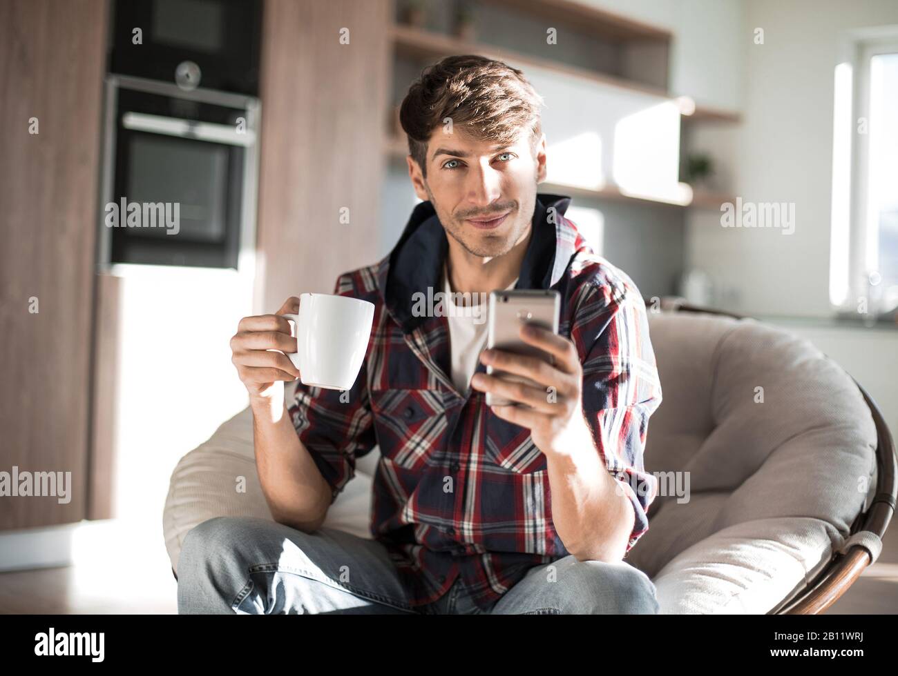 attractive guy drinks tea sitting in a comfortable chair Stock Photo ...