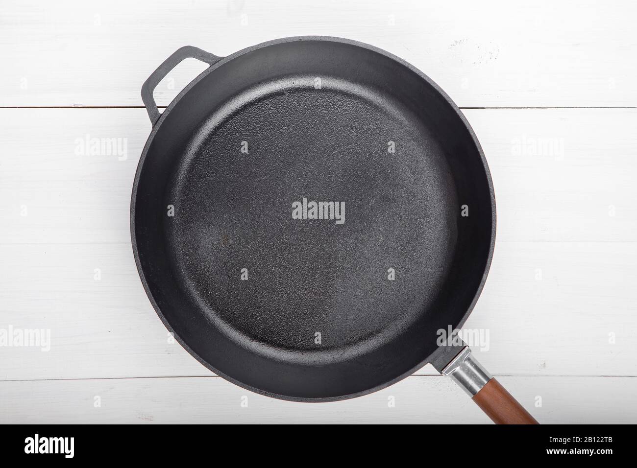 Cast-iron wok pan on a white table. View from above Stock Photo - Alamy