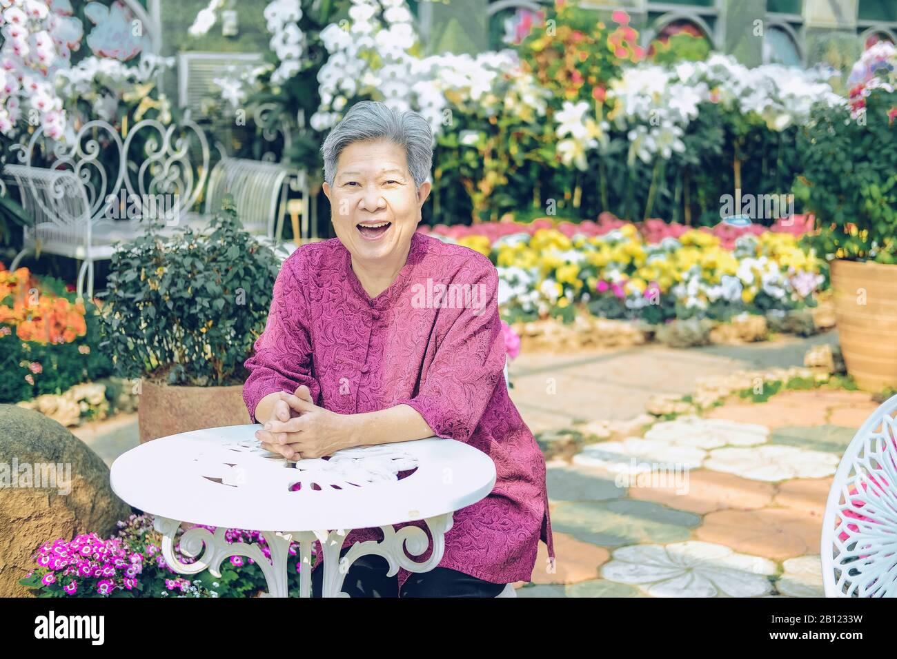old elder woman resting in flower garden. asian elderly female relaxing ...