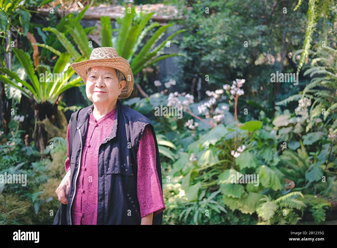 old elder woman resting in flower garden. asian elderly female relaxing ...