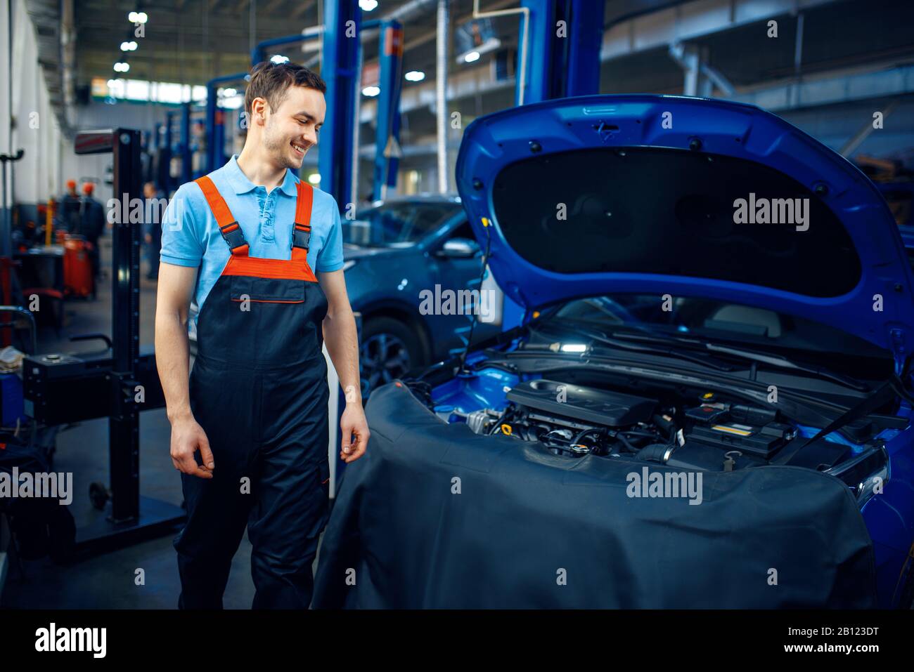 Repairman at vehicle with opened hood, car service Stock Photo - Alamy