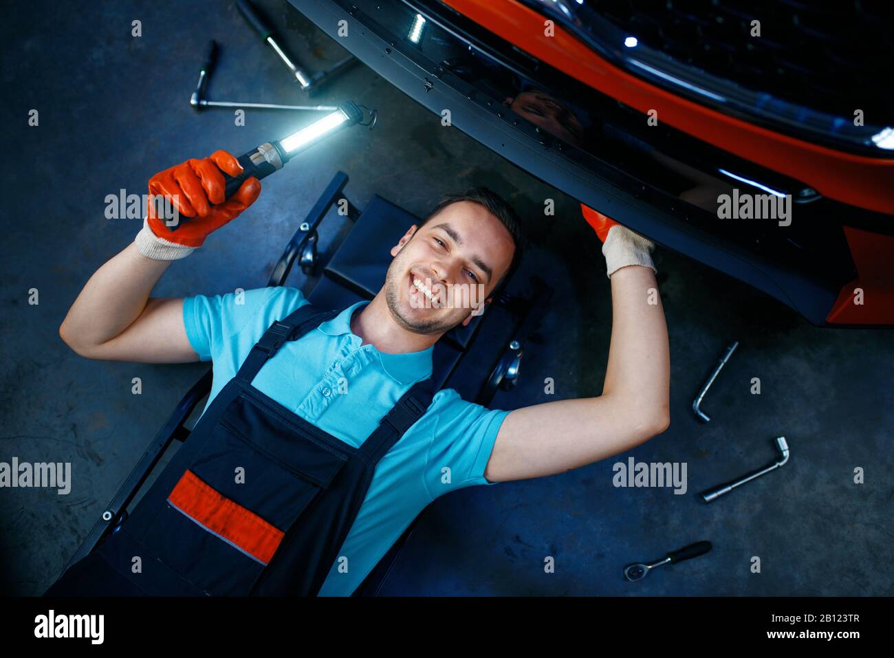 Worker lying under the vehicle, car service Stock Photo - Alamy