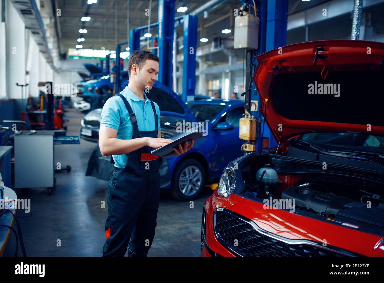 Worker with a checklist, car service station Stock Photo - Alamy