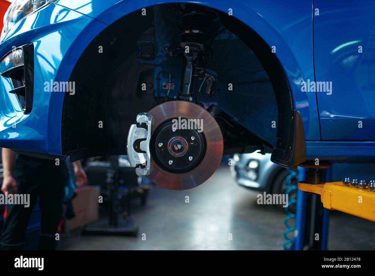 Vehicle with removed wheel on lift, car service Stock Photo - Alamy