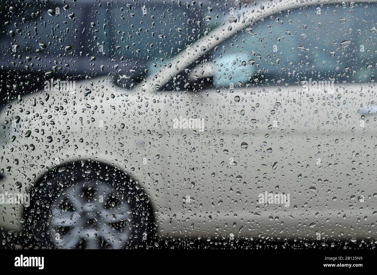 Raindrops on the glass window with outline of a car Stock Photo - Alamy
