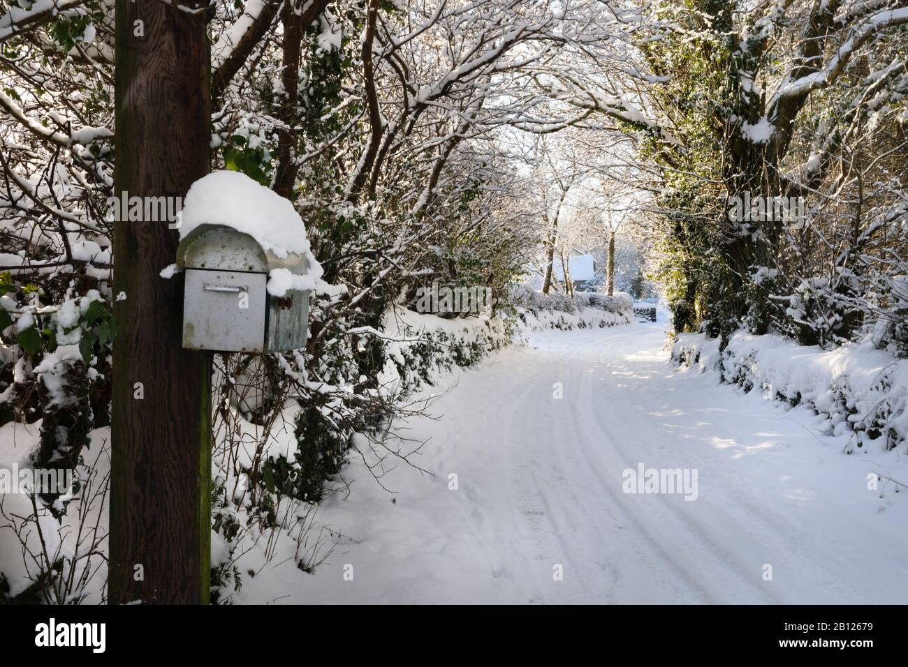 Snow covered mailbox/letter box in snow covered country lane. Attached ...