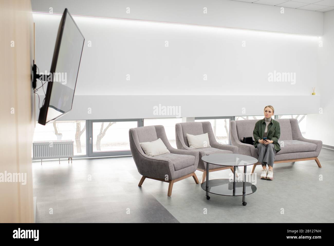 Woman sitting on couch inside hi-res stock photography and images - Alamy
